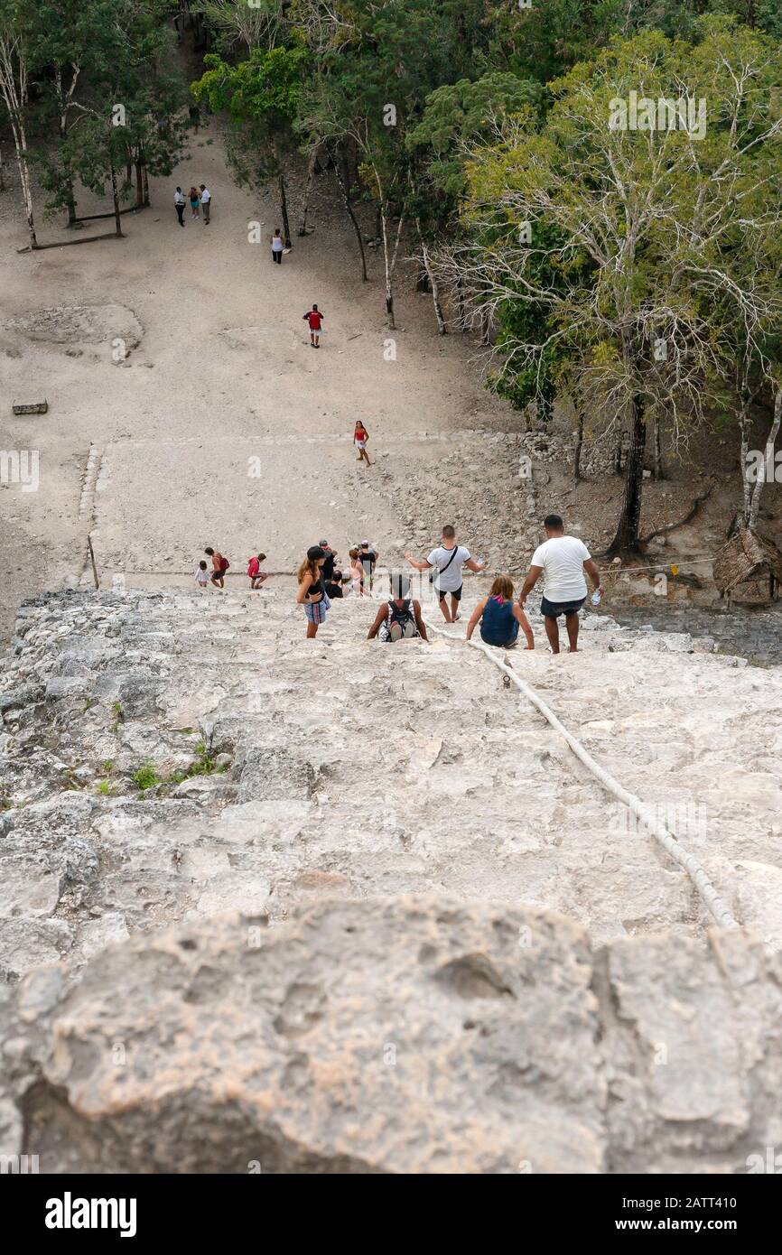 People are climbing down the steep steps of the Nohoch Mul Pyramid at ...