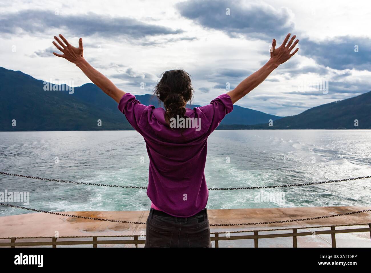 Close up from behind of a man on the deck of a passenger ferryboat ...