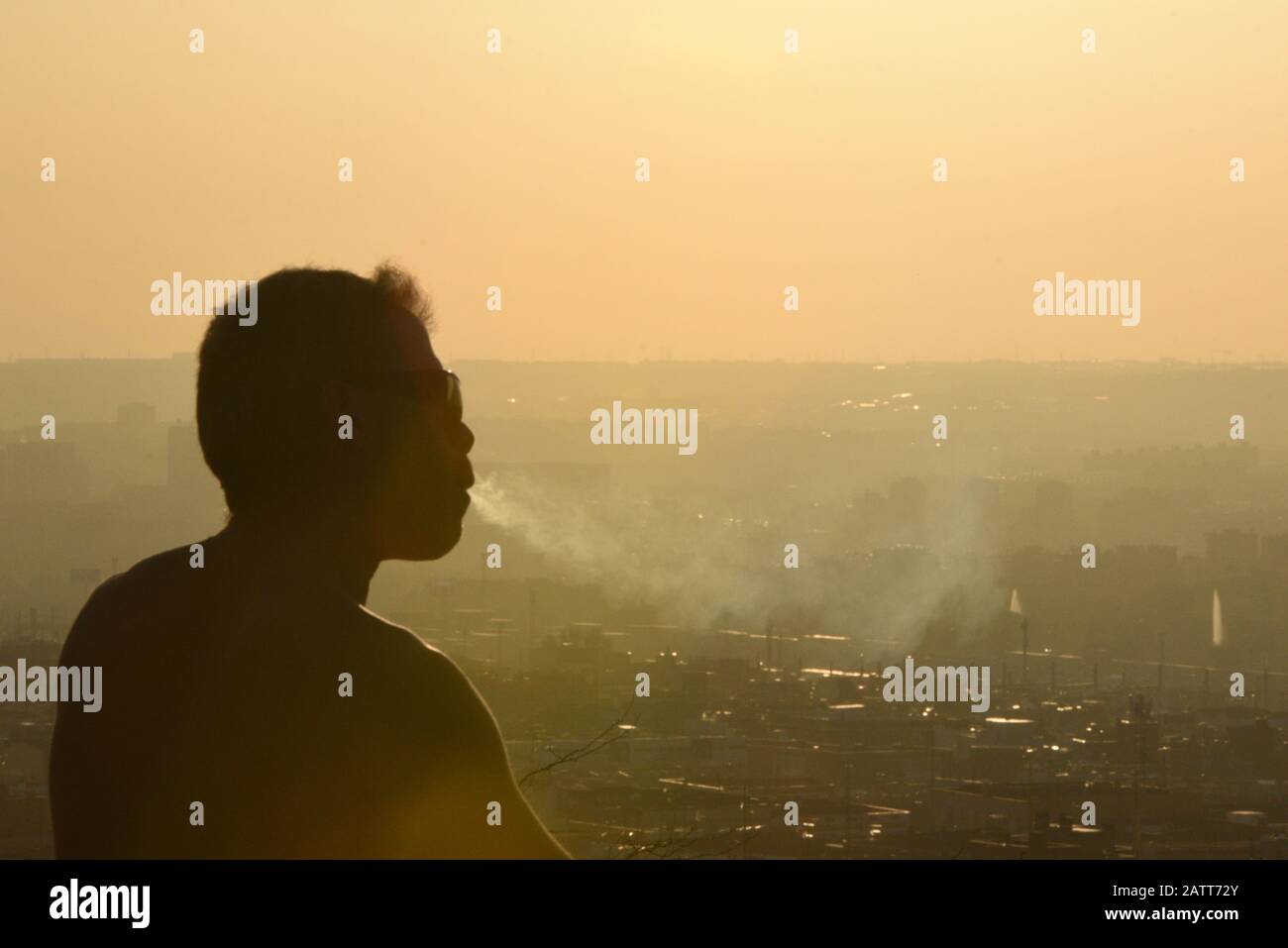 Madrid, Spain. 4th Feb, 2020. A man smoking at sunset amidst smog.Air ...