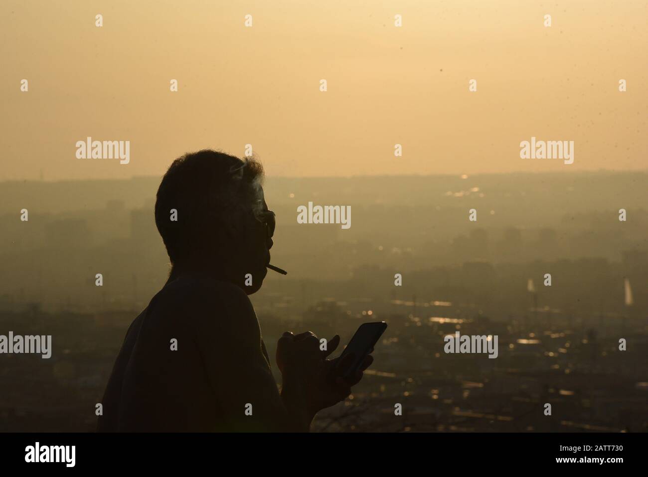 Madrid, Spain. 4th Feb, 2020. A man smoking at sunset amidst smog.Air ...