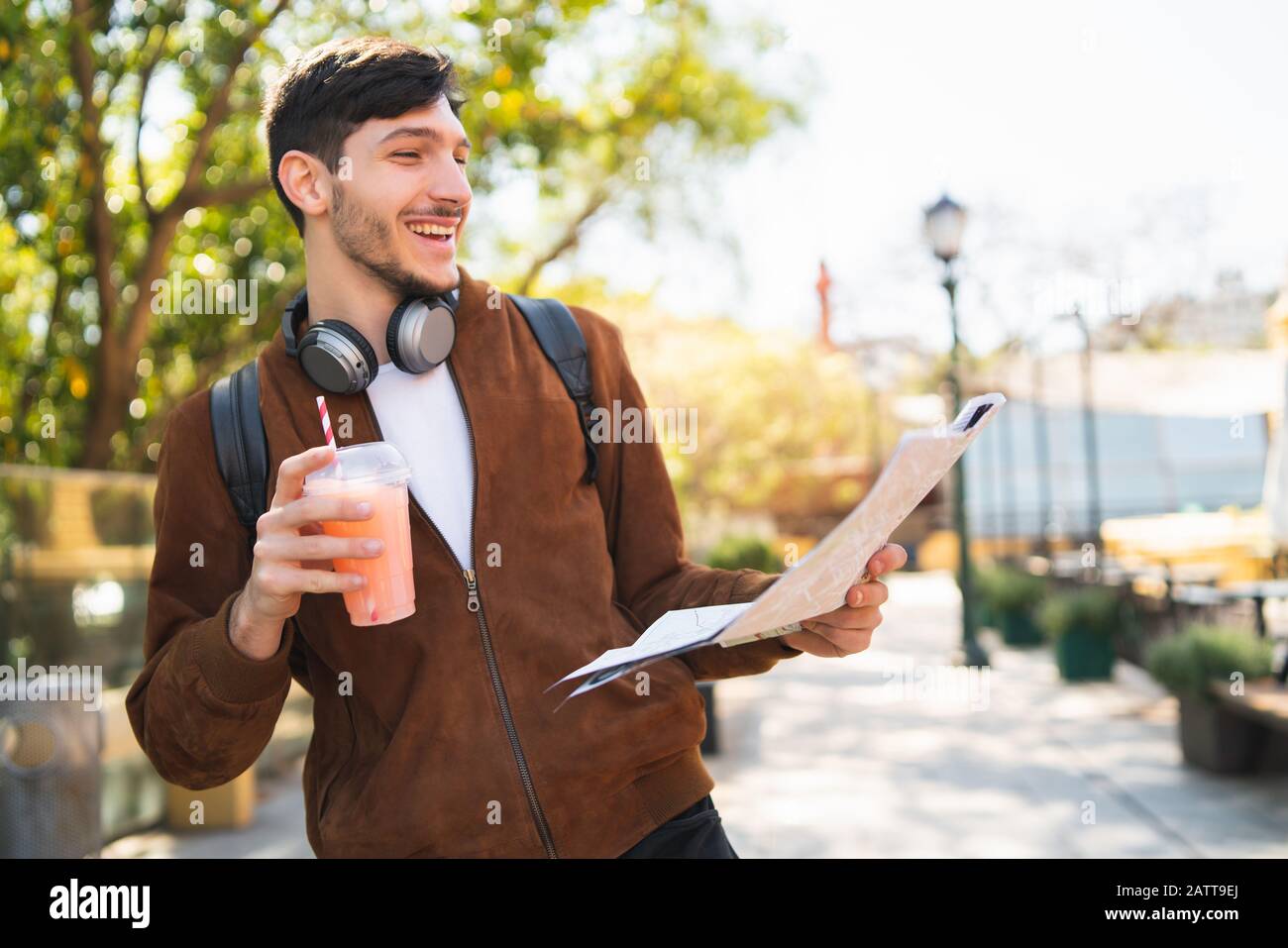 Portrait of young traveler man holding a map and looking for directions ...