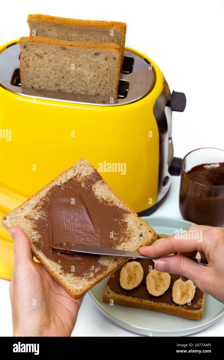 bright, fun breakfast. girl preparing toasts. yellow toaster and a cup ...