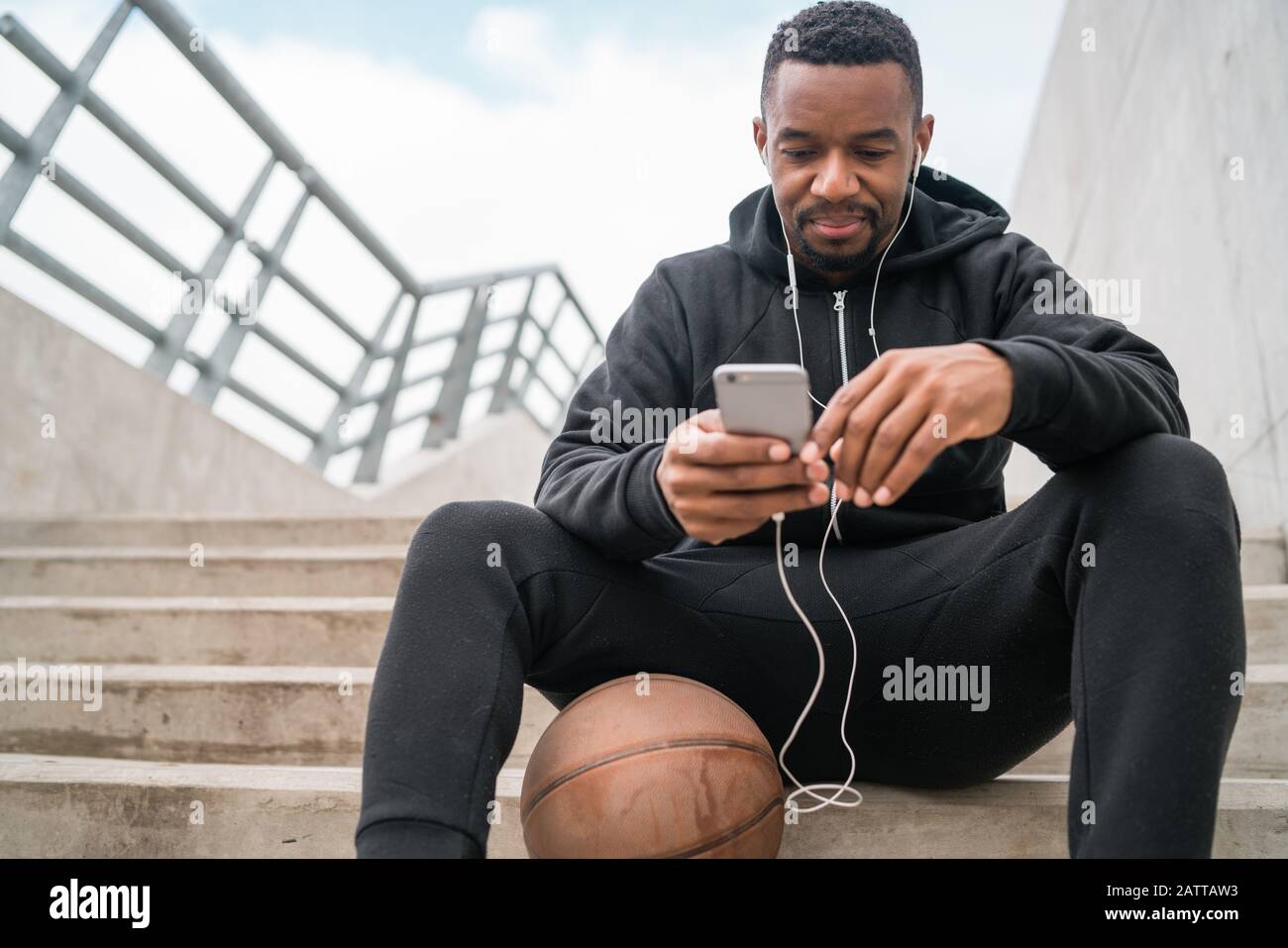 Portrait of an athletic man using his mobile phone on a break from ...