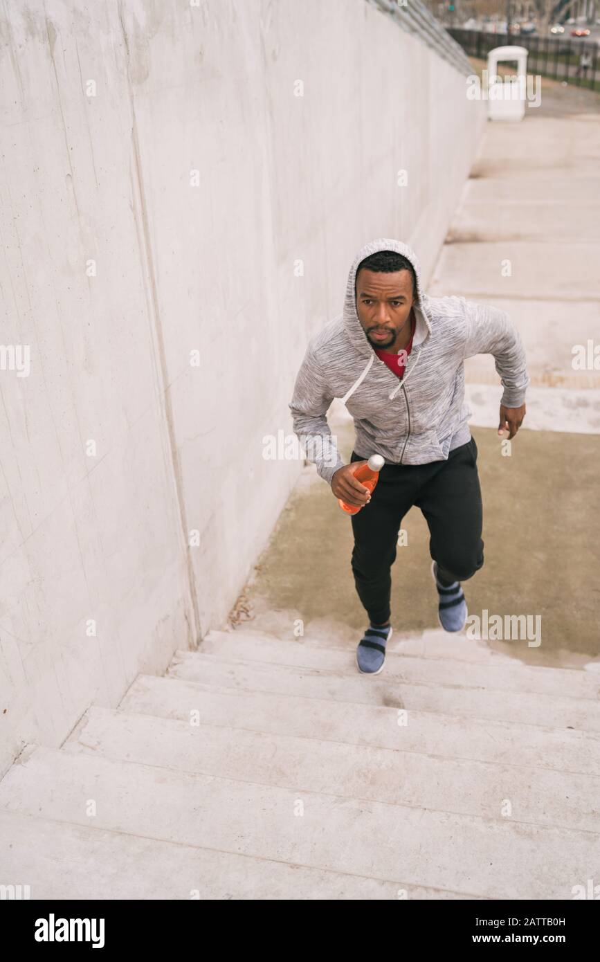 Portrait of a sport man running up on stairs outdoors. Fitness, sport ...