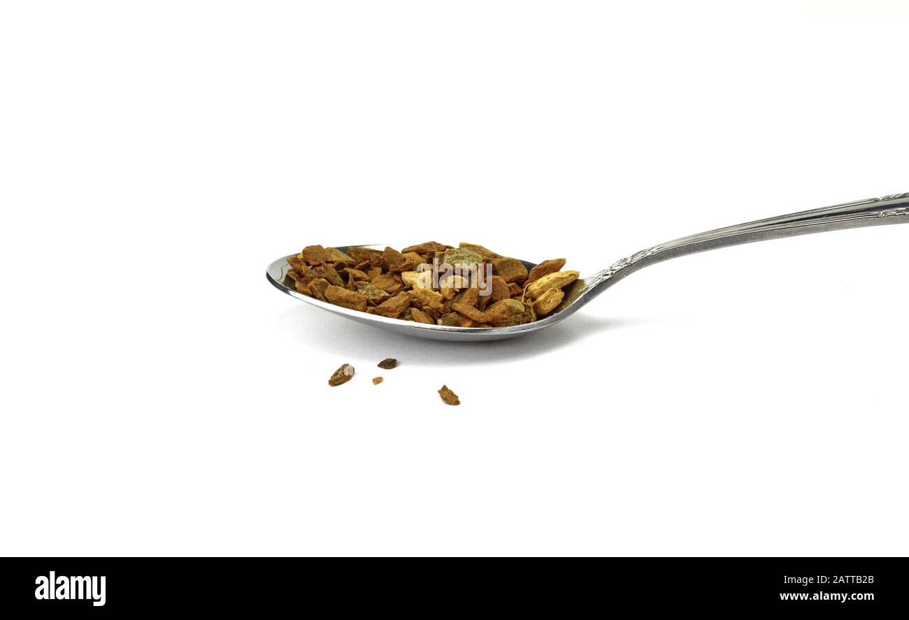Indian chai tea, cinamon and ginger in a metal spoon isolated on white ...