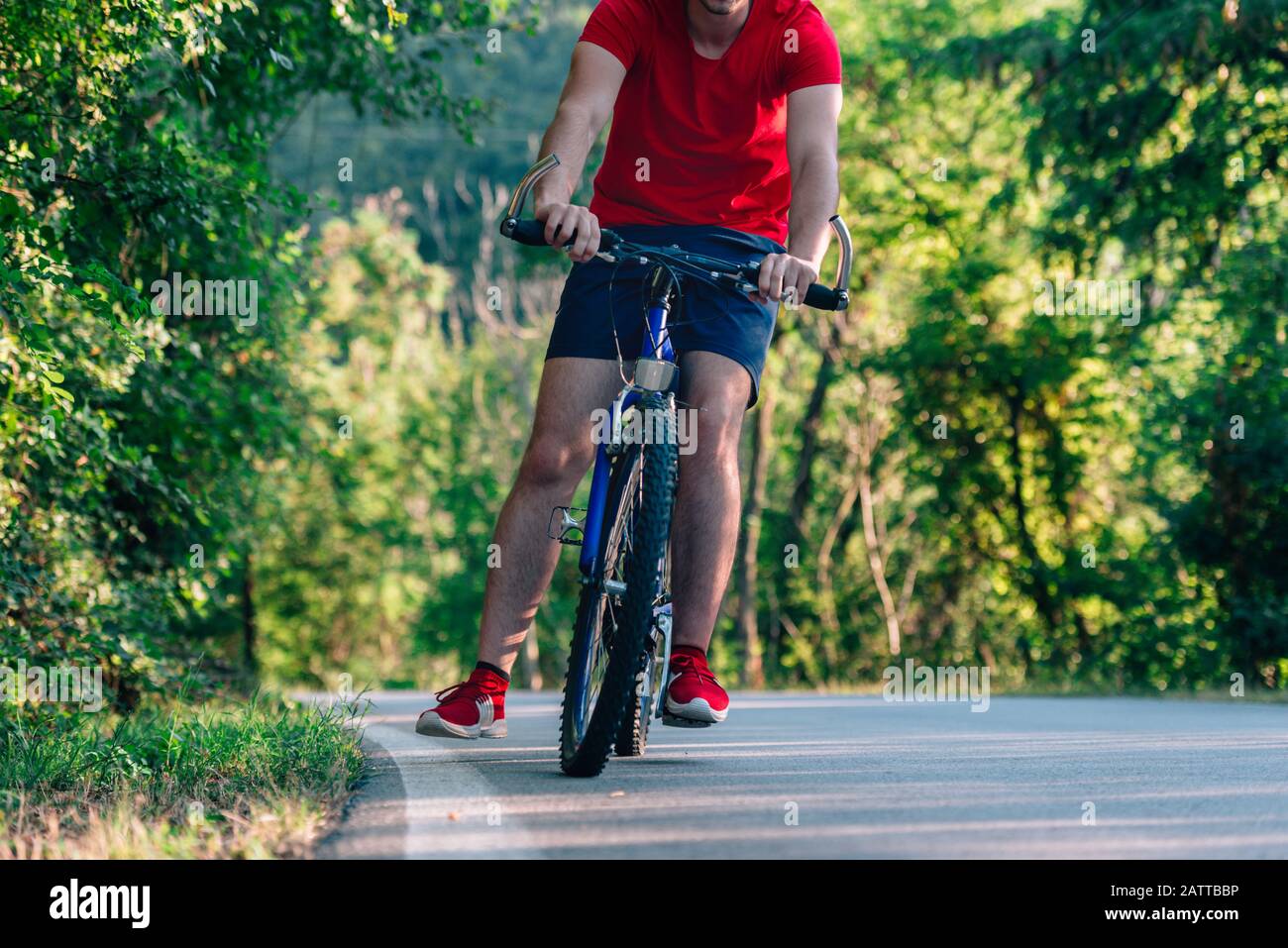 Happy biker cyclist riding his bike through the green woods Stock Photo ...
