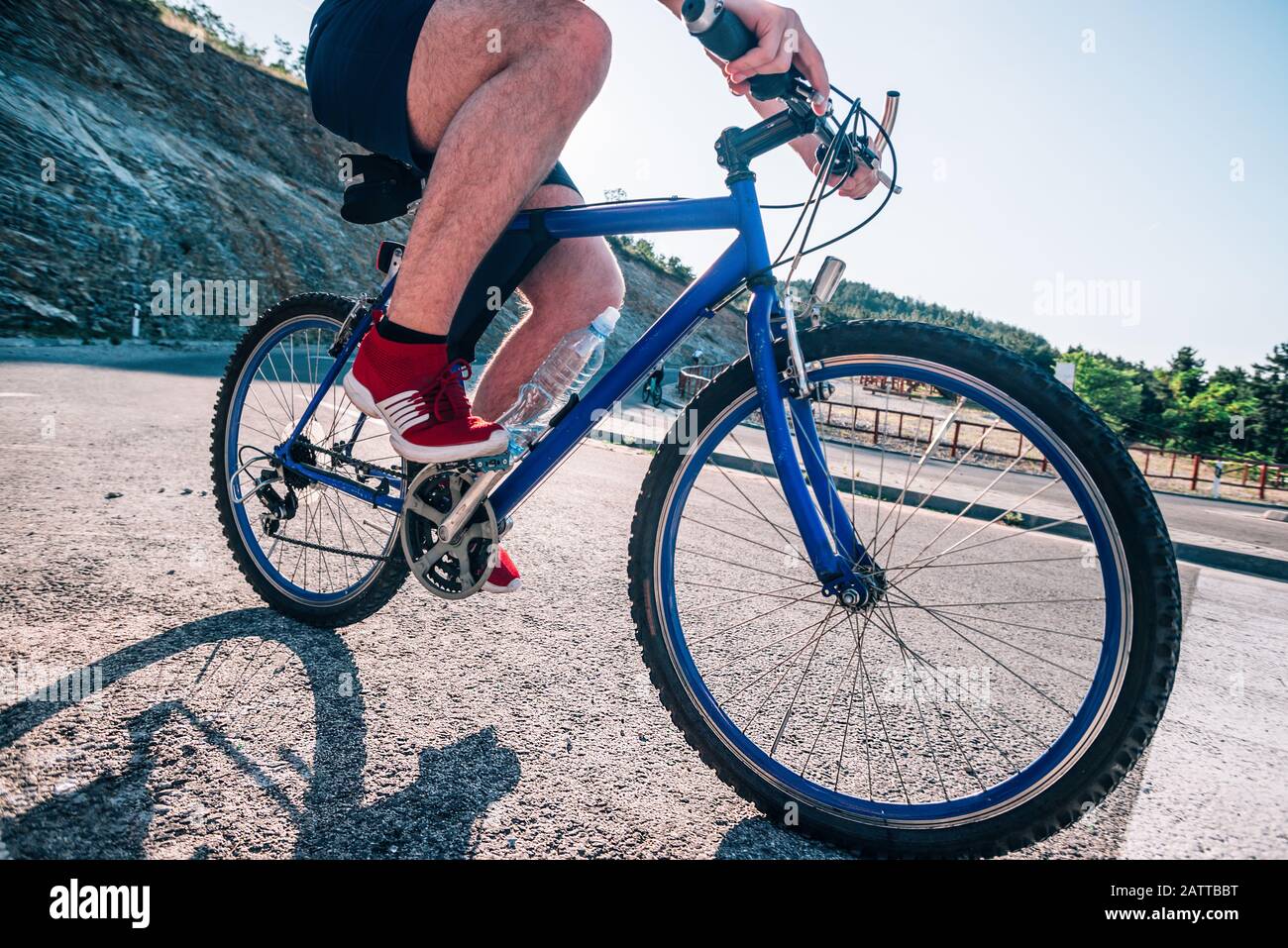 Fit male biker cyclist riding his bike cycle on an asphalt road at ...