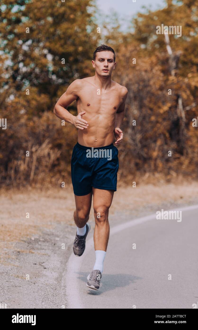 Man running sprinting on road in mountains. Fit male fitness runner ...