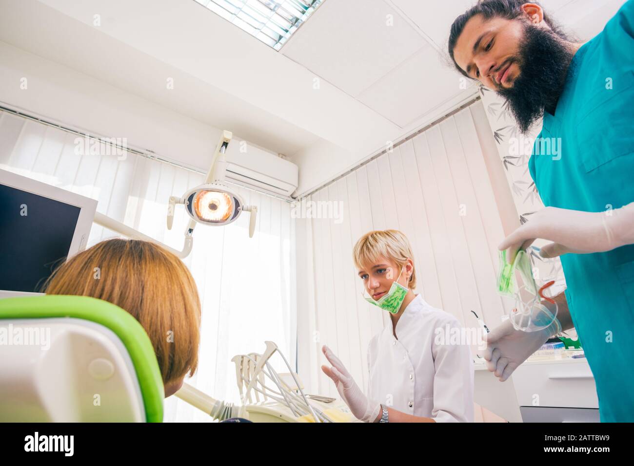 Professional dentists explaining a dental procedure to a female patient ...