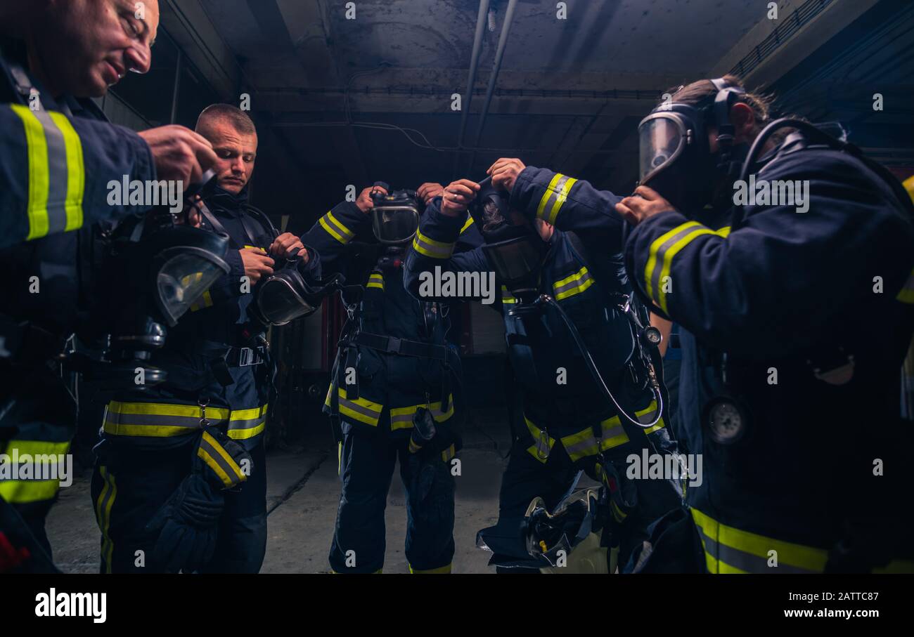 Group of firefighters standing inside the fire brigade wearing helmet ...