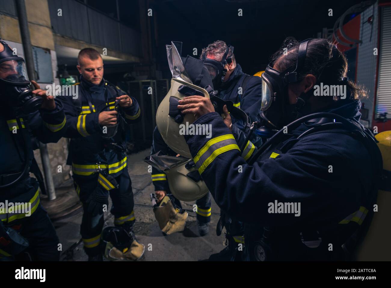 Group of firefighters standing inside the fire brigade wearing helmet ...