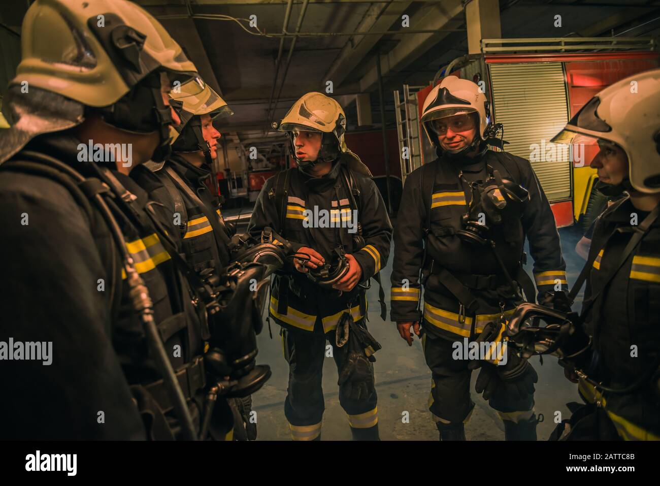 Group of firefighters with uniform inside the fire station preparing ...