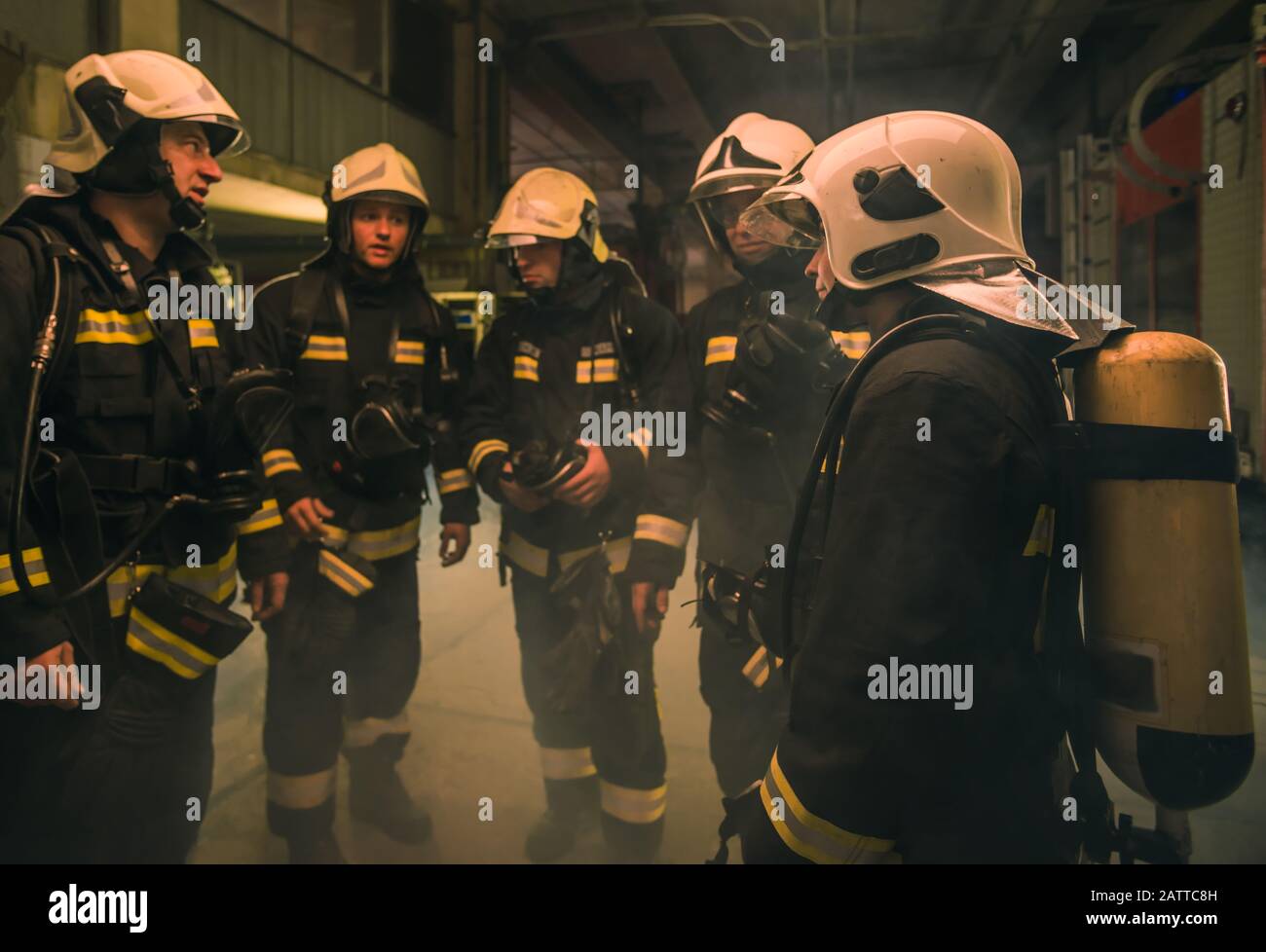 Group of firefighters with uniform inside the fire station preparing ...