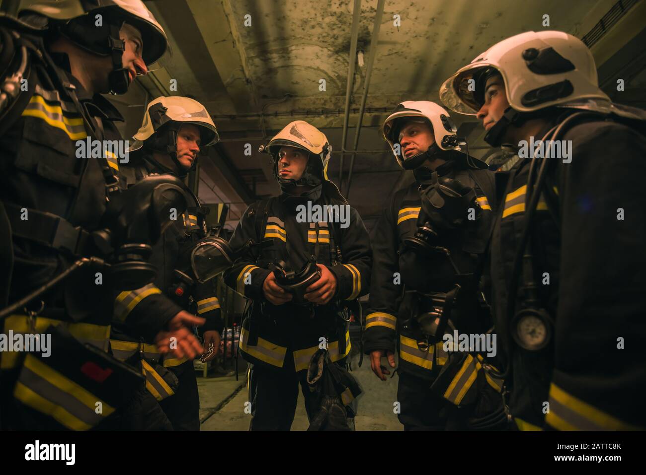 Group of firefighters with uniform inside the fire station preparing ...