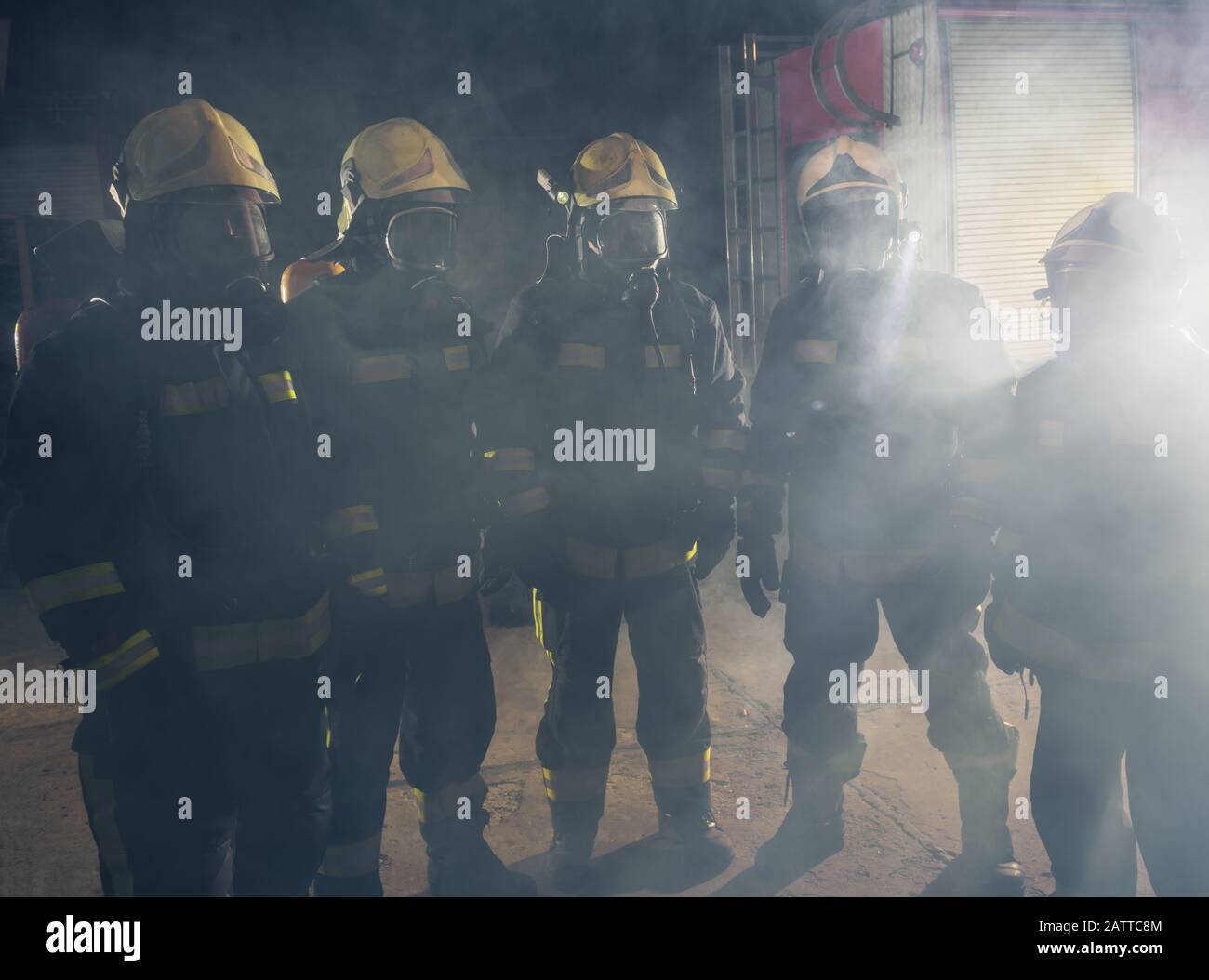 Portrait of group of firefighters in the middle of the smoke of the ...