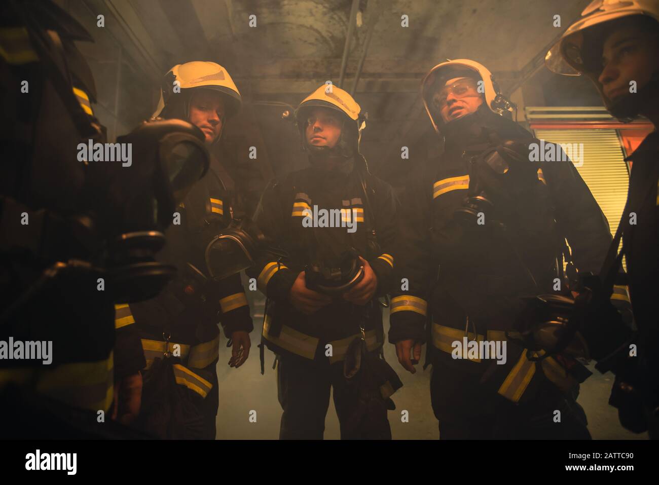 Group of firefighters with uniform inside the fire station preparing ...