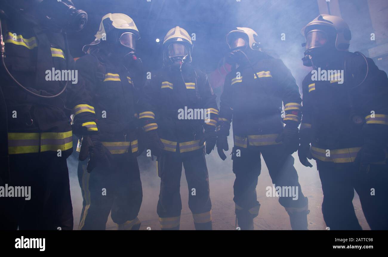 Portrait of group of firefighters in the middle of the smoke of the ...