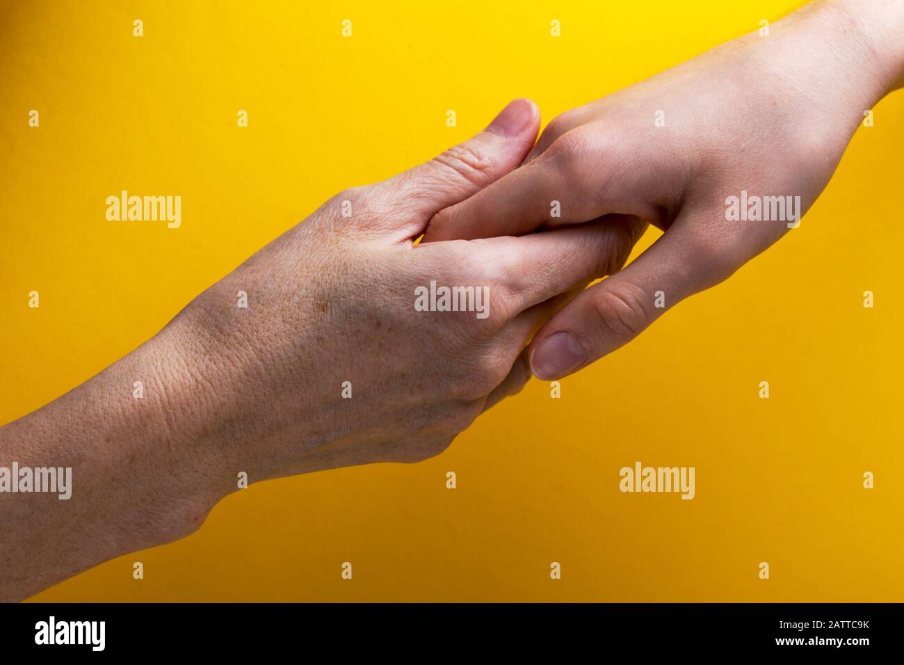 hands on a yellow background. reach out for help Stock Photo - Alamy