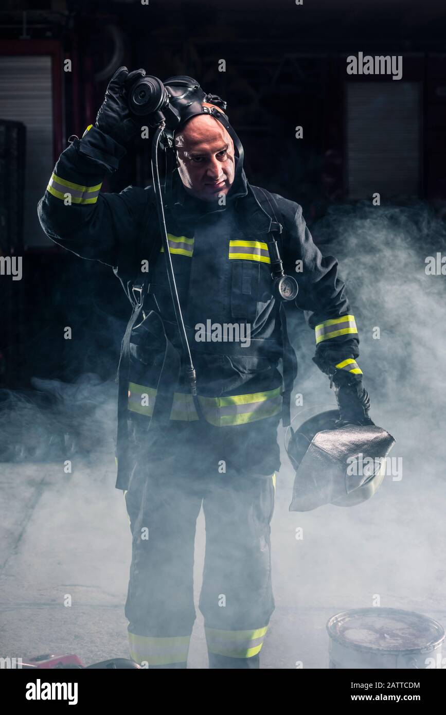 Fireman standing confident holding helmet and wearing firefighter ...