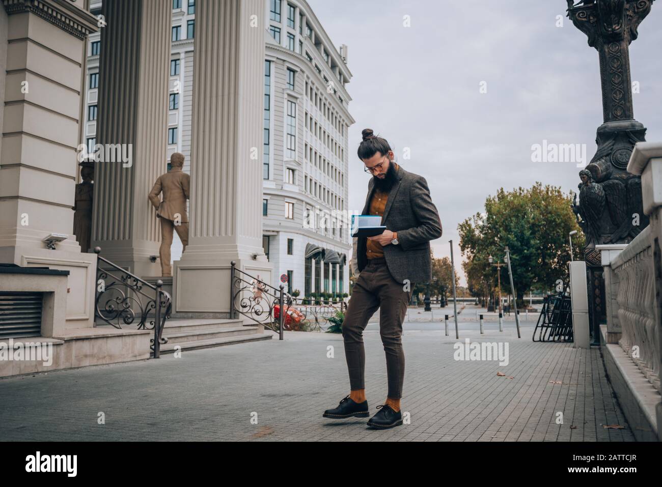 Modern day hipster reading a book outdoors at the promenade Stock Photo ...