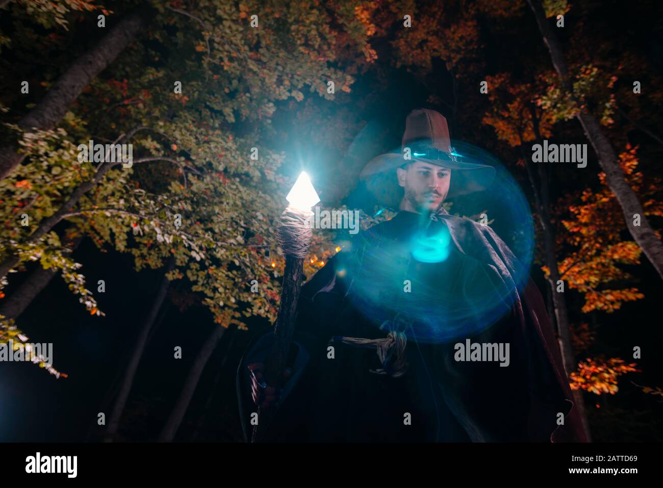 Sorcerer (magician) casting a spell while standing in the magical woods ...