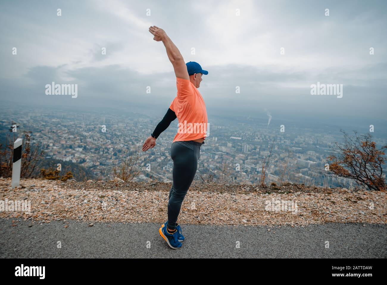 Healthy fit middle aged runner during a warm up routine before running ...