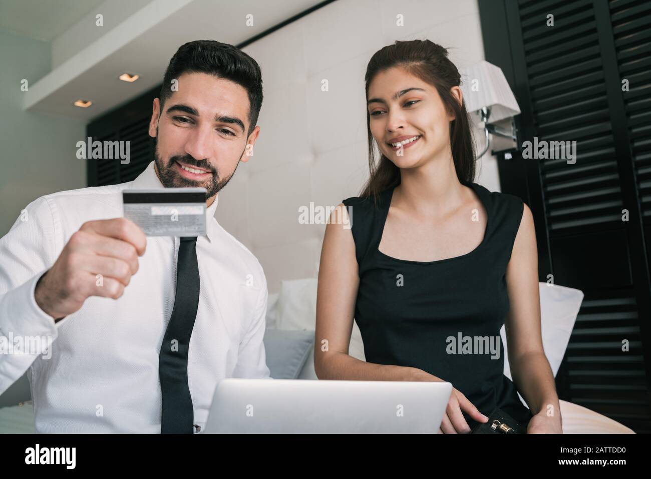 Portrait of two young business people using credit card for online ...