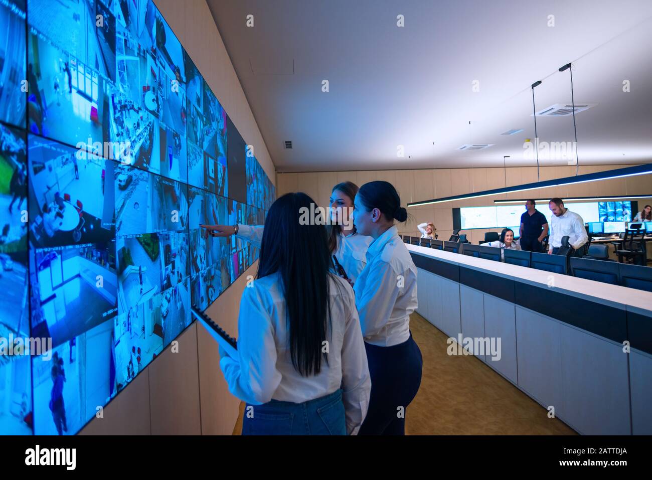 Security guards standing in front of a large CCTV monitor at the main ...