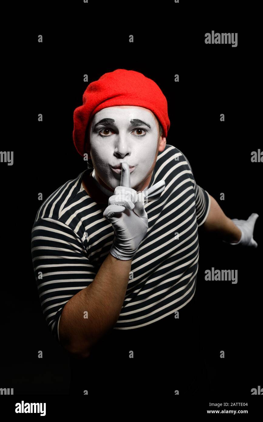 Male mime showing hush sign. Man in striped t-shirt Stock Photo - Alamy