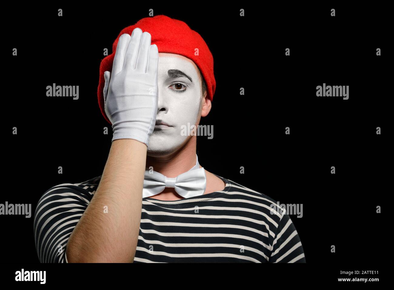 Mime covering half of face with hand Stock Photo - Alamy