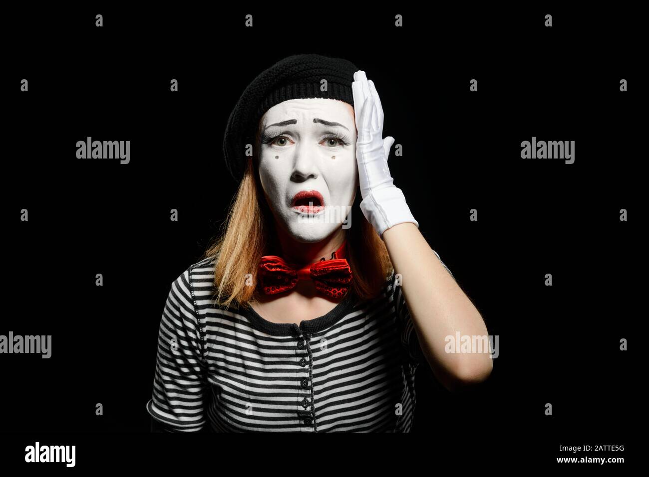 Upset female mime on black. Woman is touching her head Stock Photo - Alamy