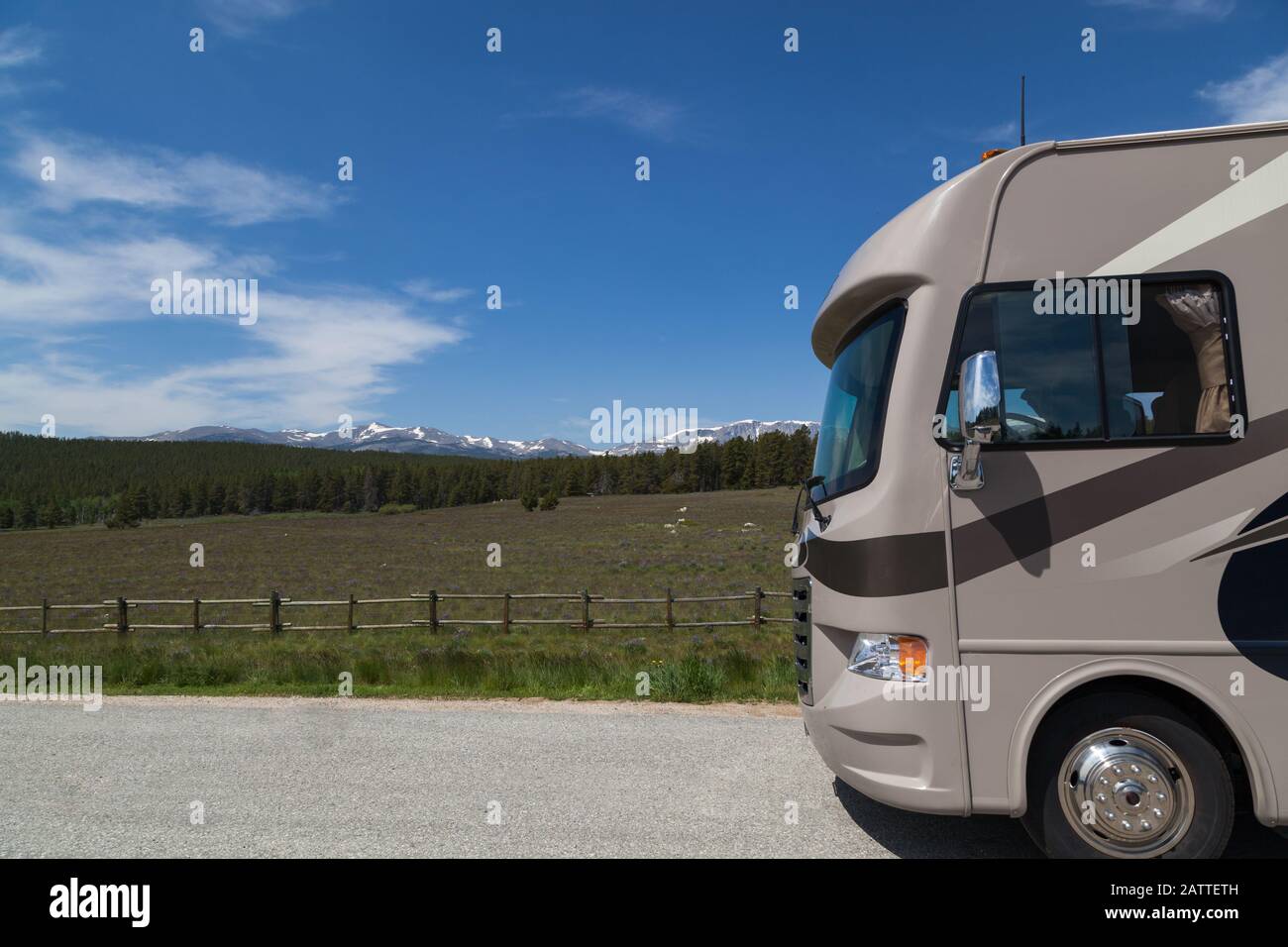 The front of a large motorhome next to a pretty green field with a ...