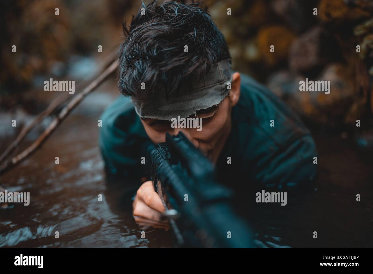 The hunter or soldier who got into the water is aiming with his gun ...