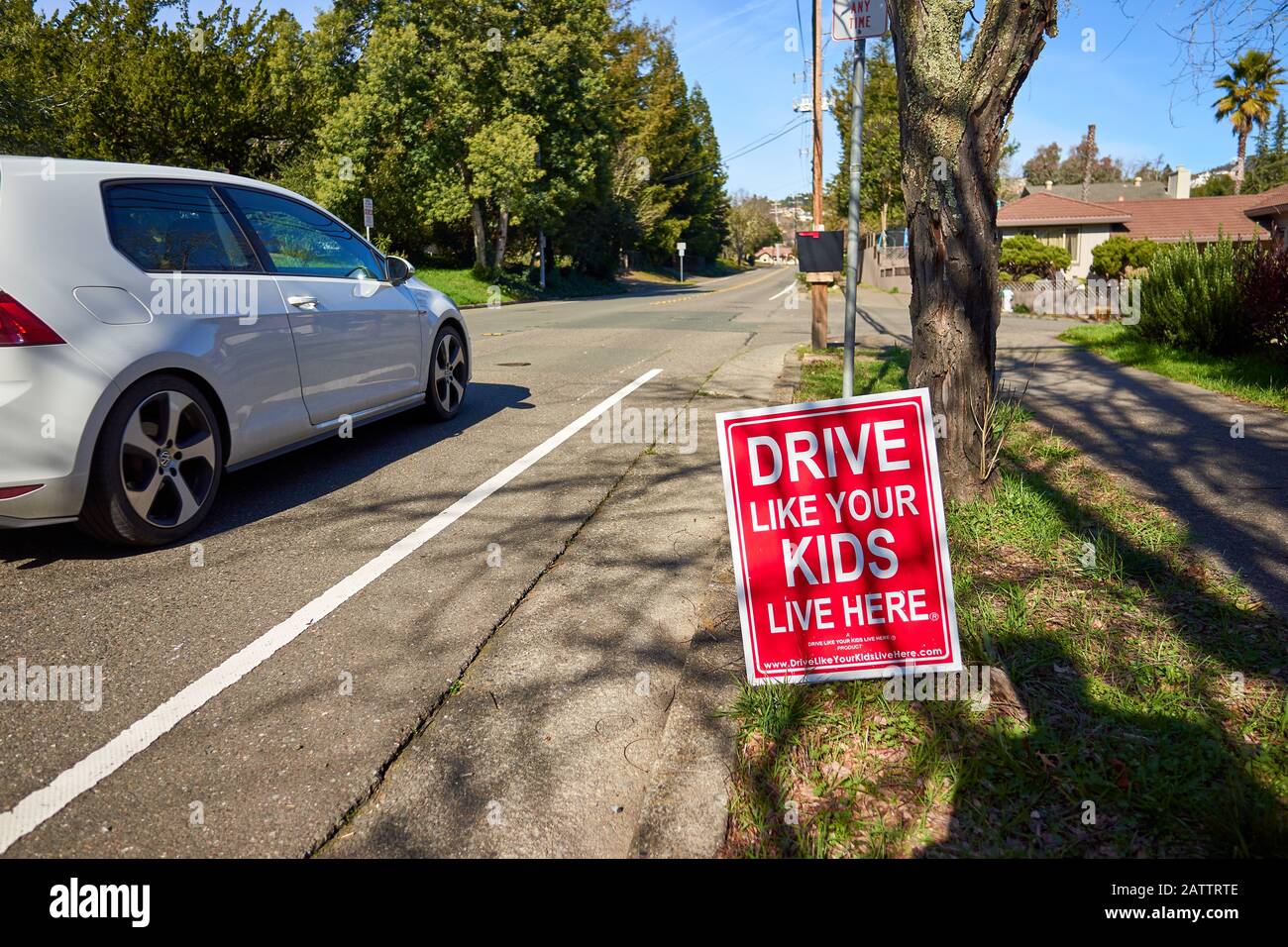 A roadside sign alerting drivers reads DRIVE LIKE YOUR KIDS LIVE HERE ...