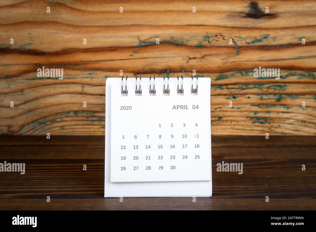 2020 April. White paper calendar on a wooden table. Time planning, day ...