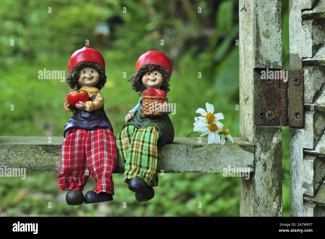 Two dolls sitting on the wooden rail Stock Photo - Alamy