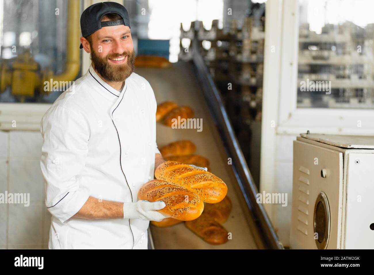 Portrait of a baker with bread in his hands against the background of a ...