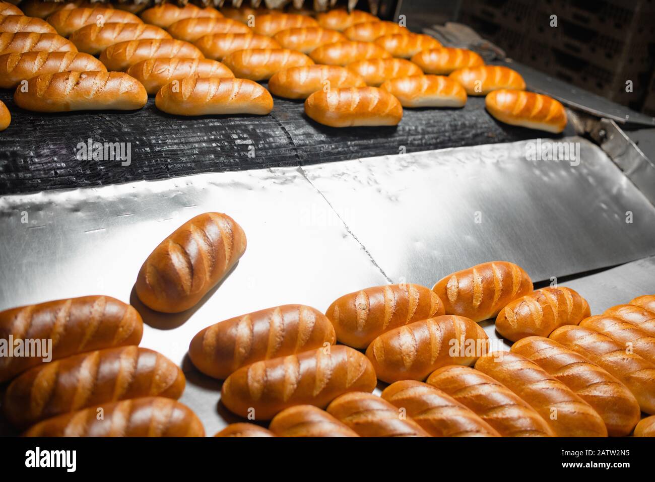 The oven in the bakery. Hot fresh bread leaves the industrial oven in a ...