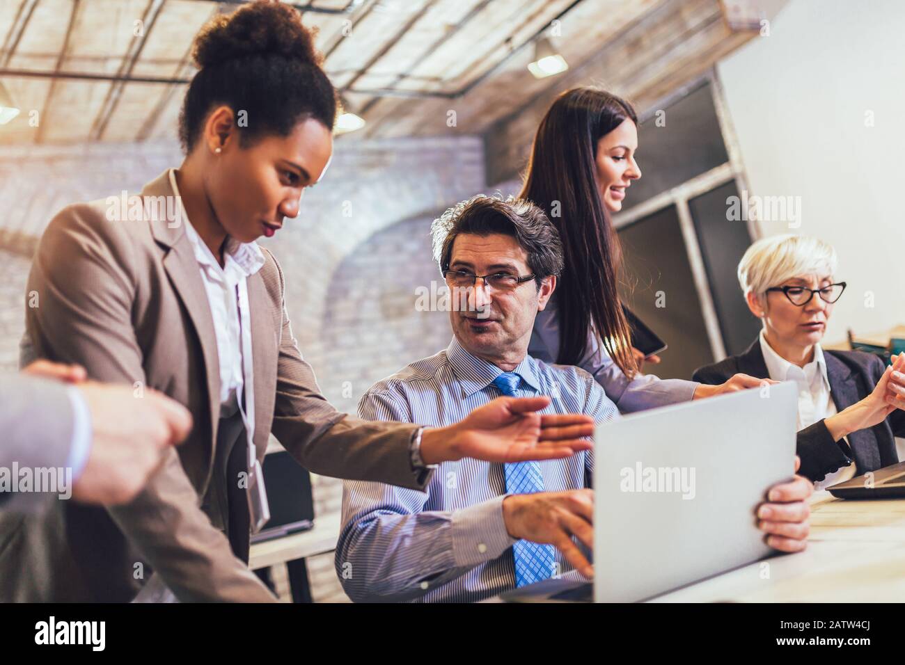 Smiling young manager helping senior worker with computer work in ...
