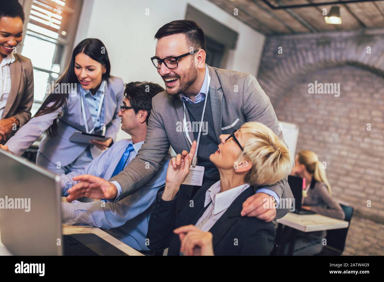 Smiling young manager helping senior worker with computer work in ...