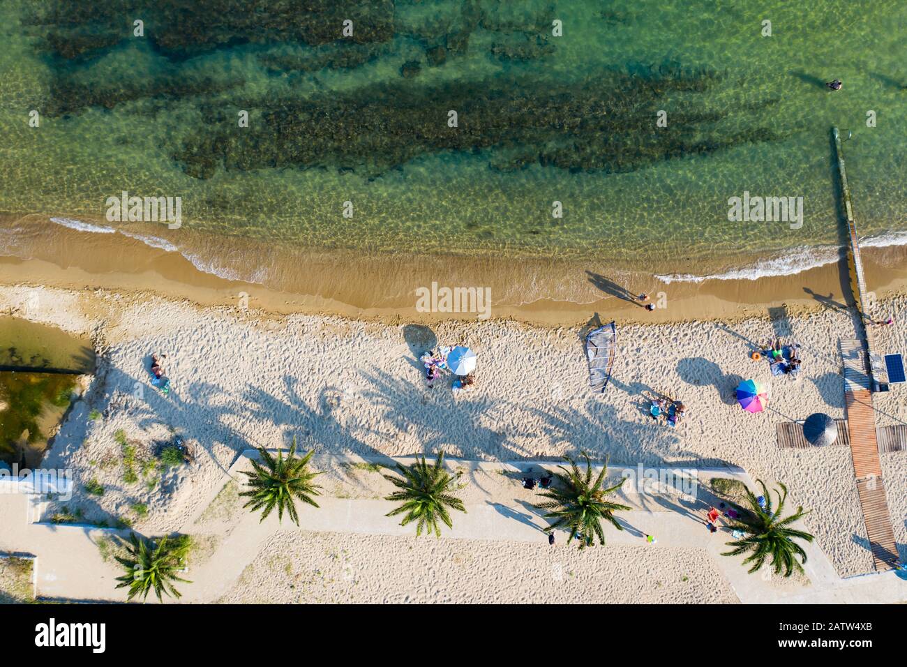 Aerial view of sandy beach with tourists swimming in beautiful clear ...