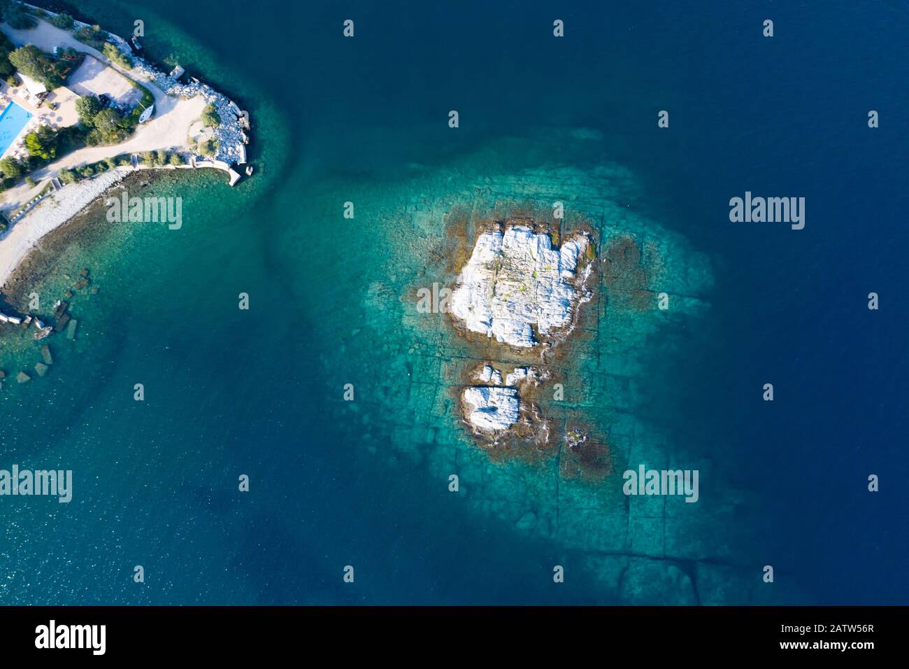 Aerial view from flying drone of a little rocky island in open sea in ...