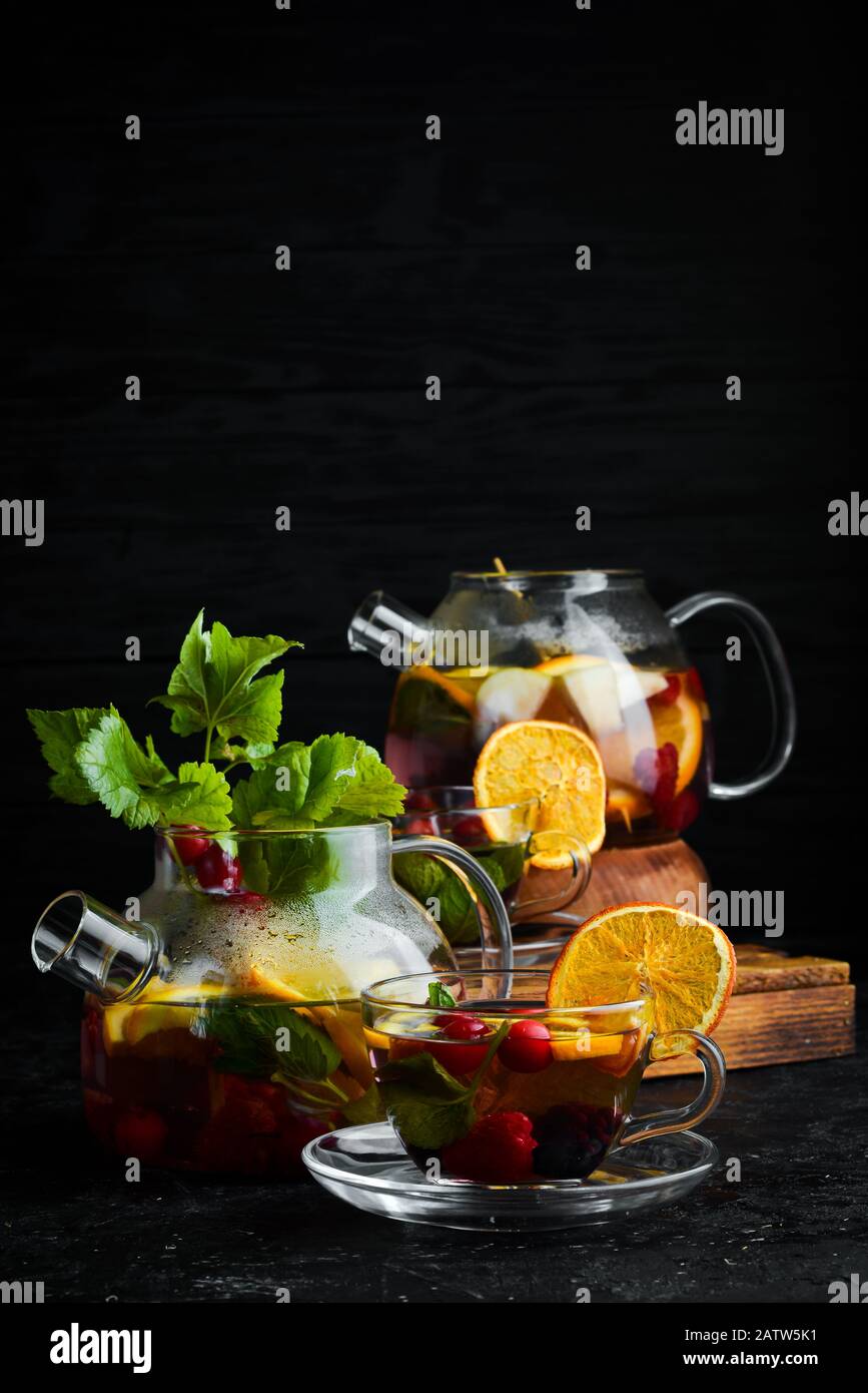 Forest berry and fruit tea. Hot winter drinks. On a black background ...