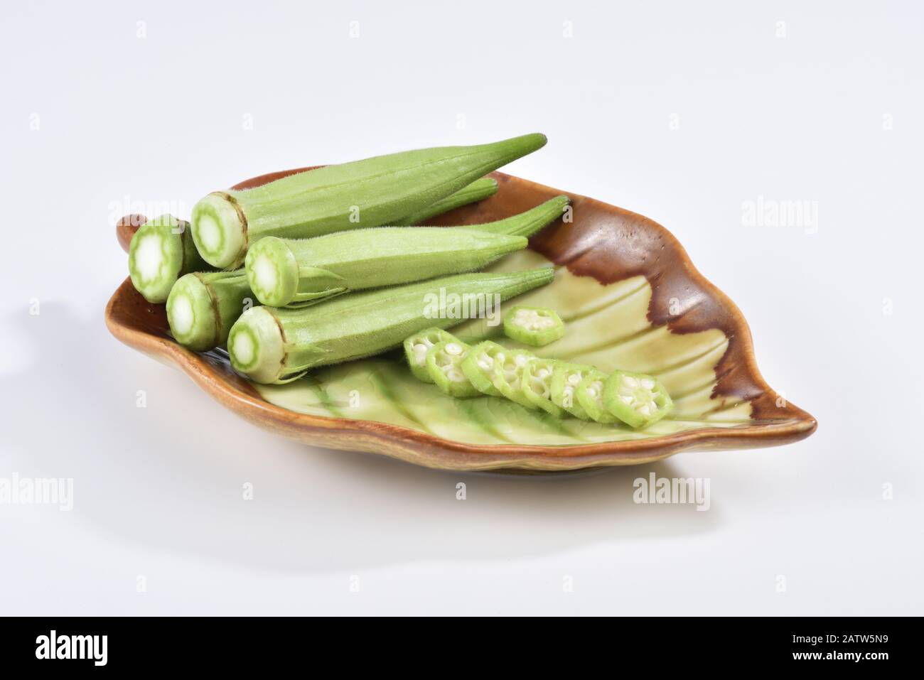okra and sliced okra on the plate at the white background Stock Photo ...