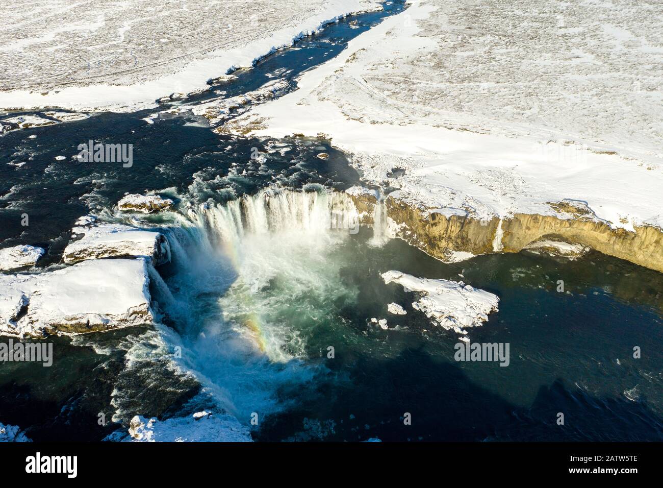 Aerial view of Godafoss waterfall, snowy shore and river. Iceland in ...