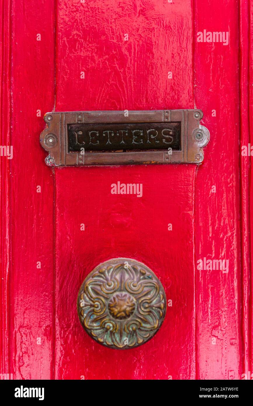 An ancient letter box on the old red door with a beautiful handle on ...