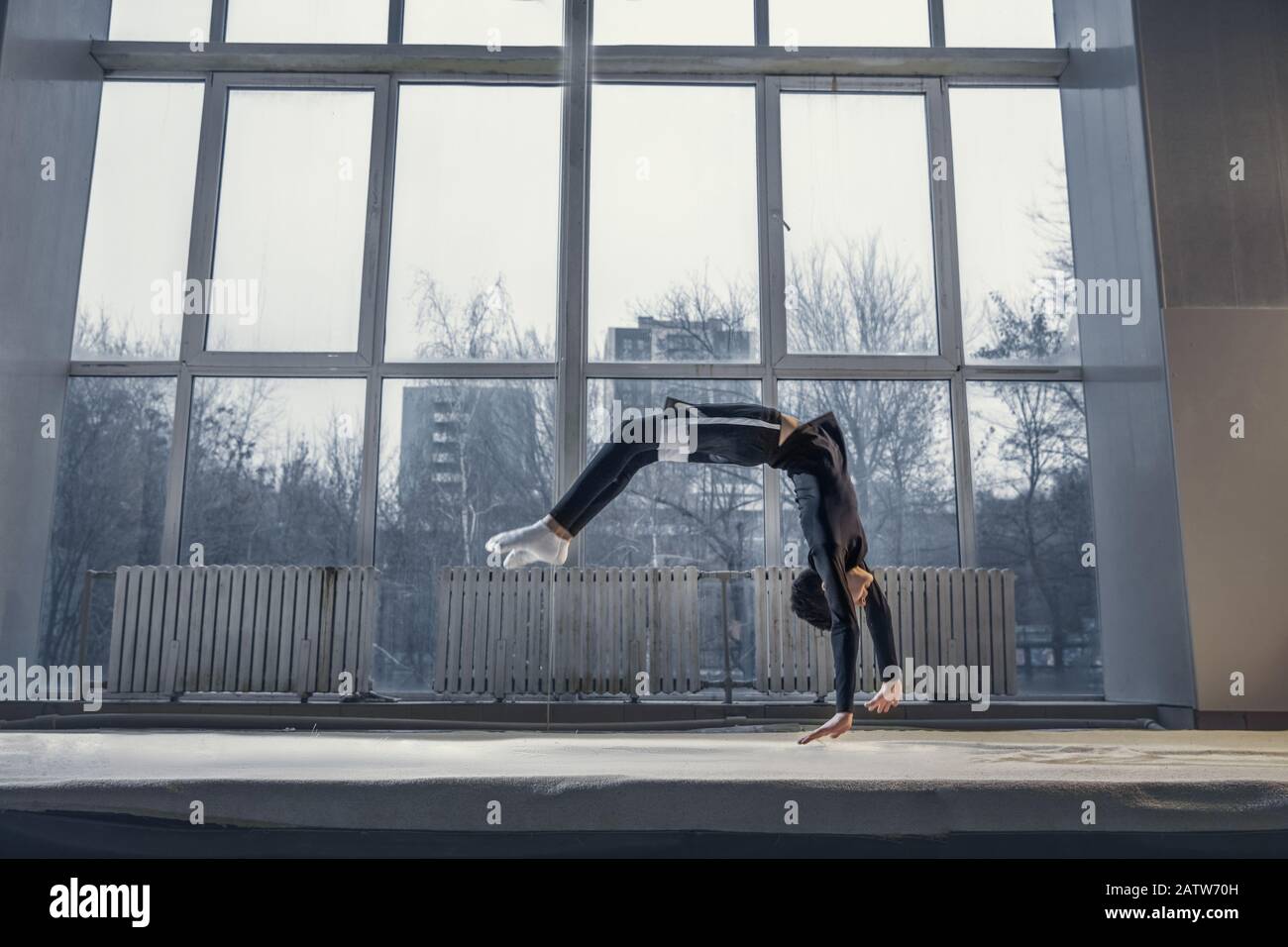 Flying. Little male gymnast training in gym, flexible and active ...