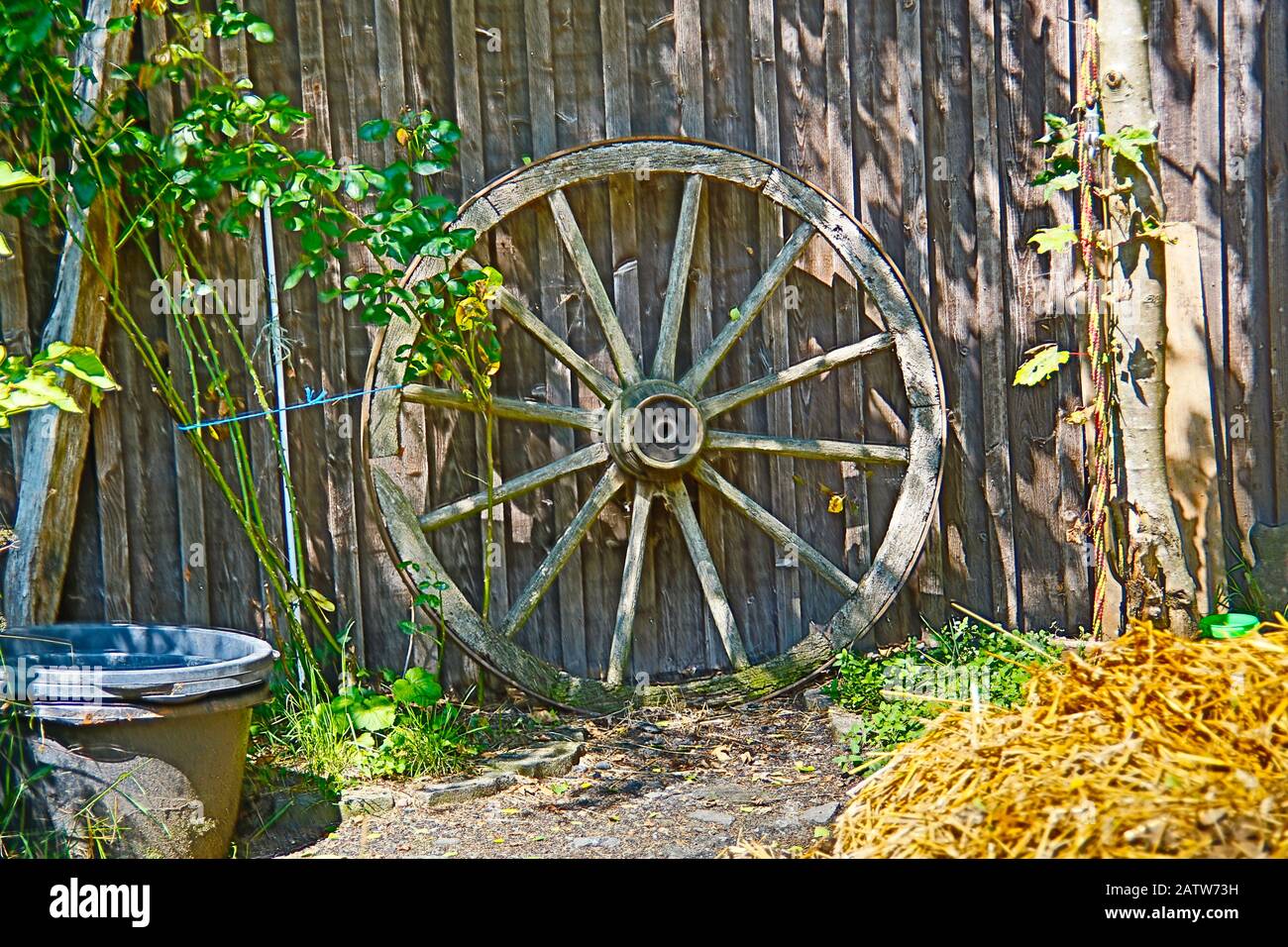 Wagon wheel leans against barn Stock Photo - Alamy