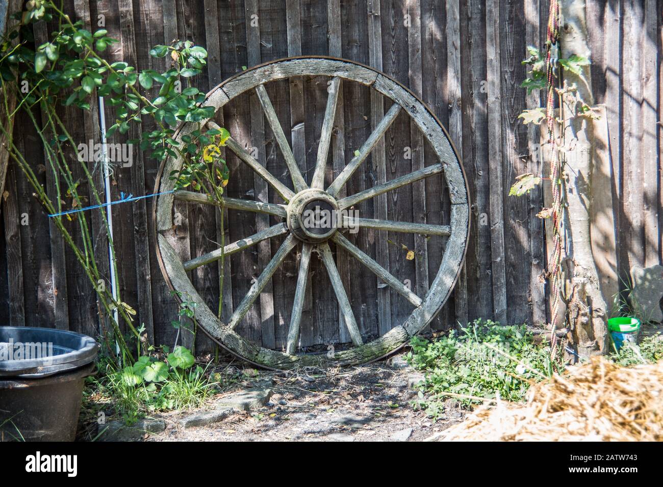 Wagon wheel leans against barn Stock Photo - Alamy