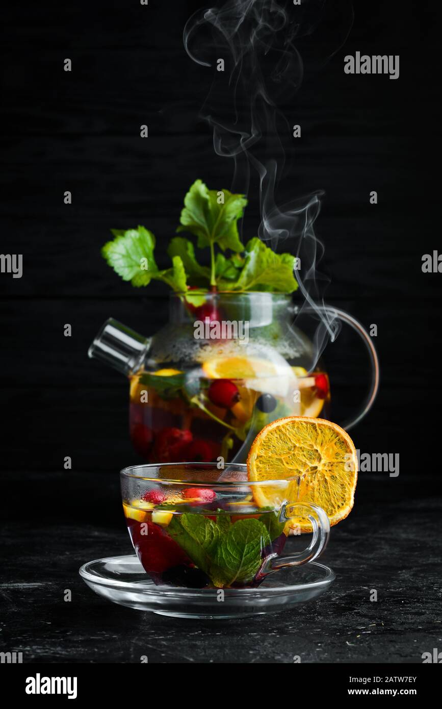 Forest berry and fruit tea. Hot winter drinks. On a black background ...